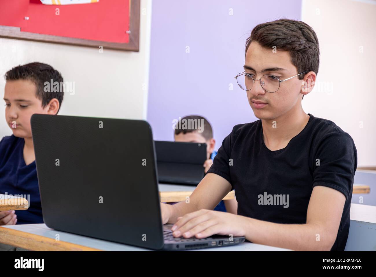 arabic teenager using laptop while studying in the school Stock Photo ...
