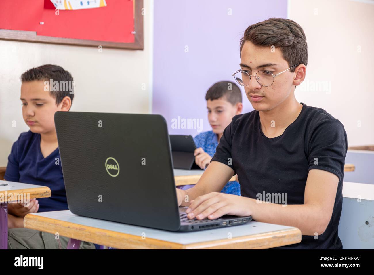 arabic teenager using laptop while studying in the school Stock Photo ...