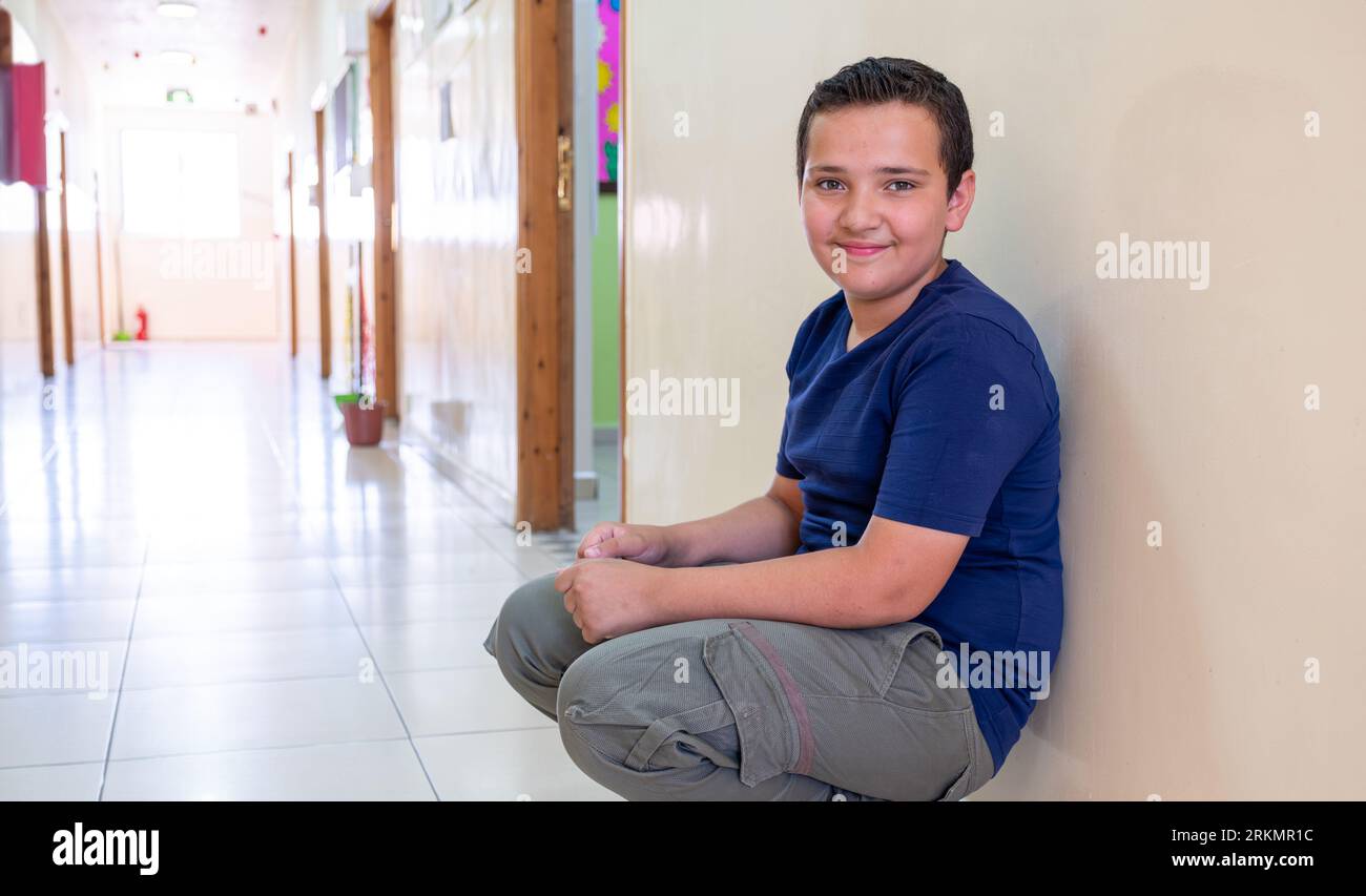 Portrait for a child sitting in the school corridor Stock Photo - Alamy