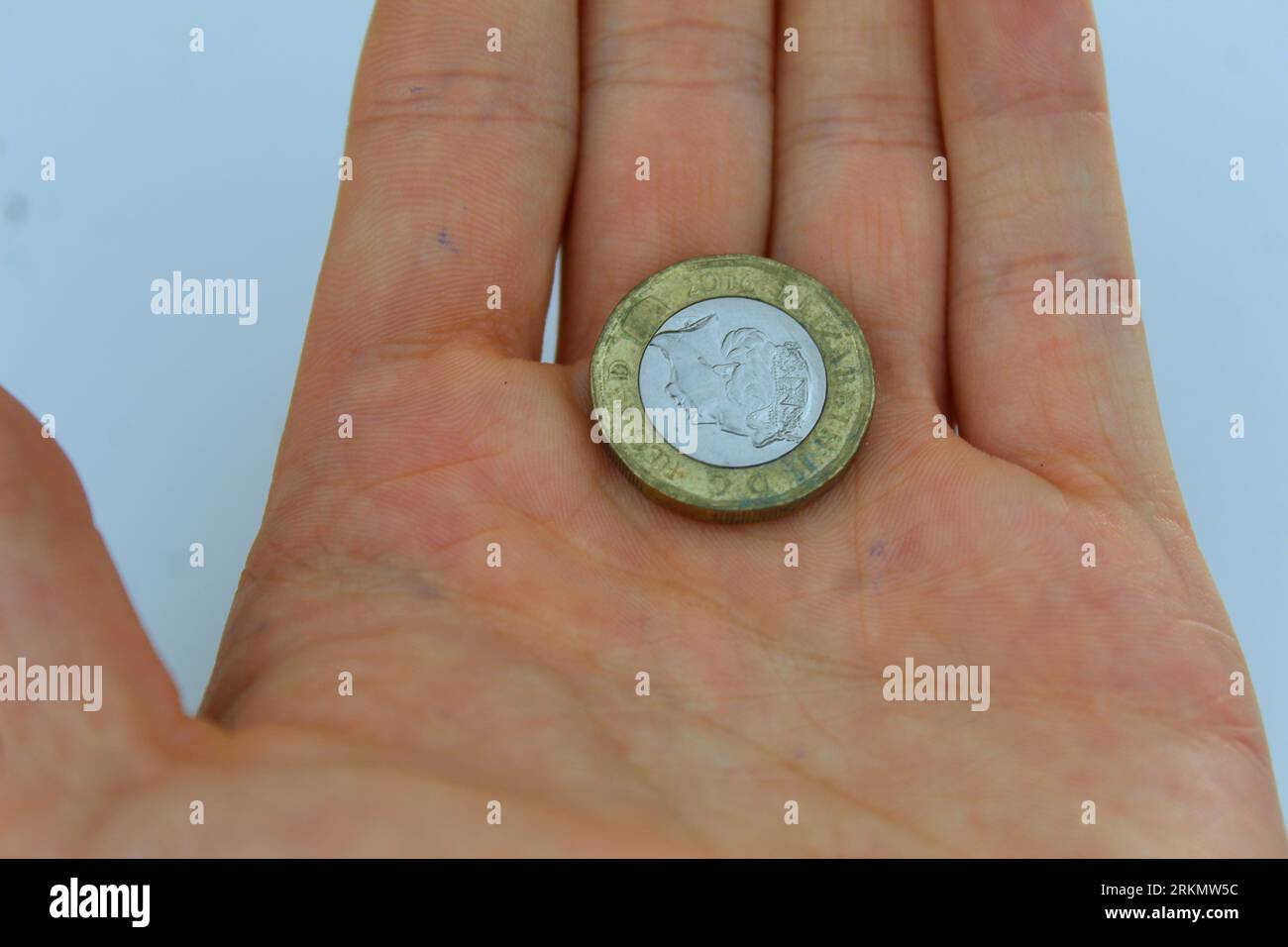 A photo of a person's hand holding a coin Stock Photo - Alamy
