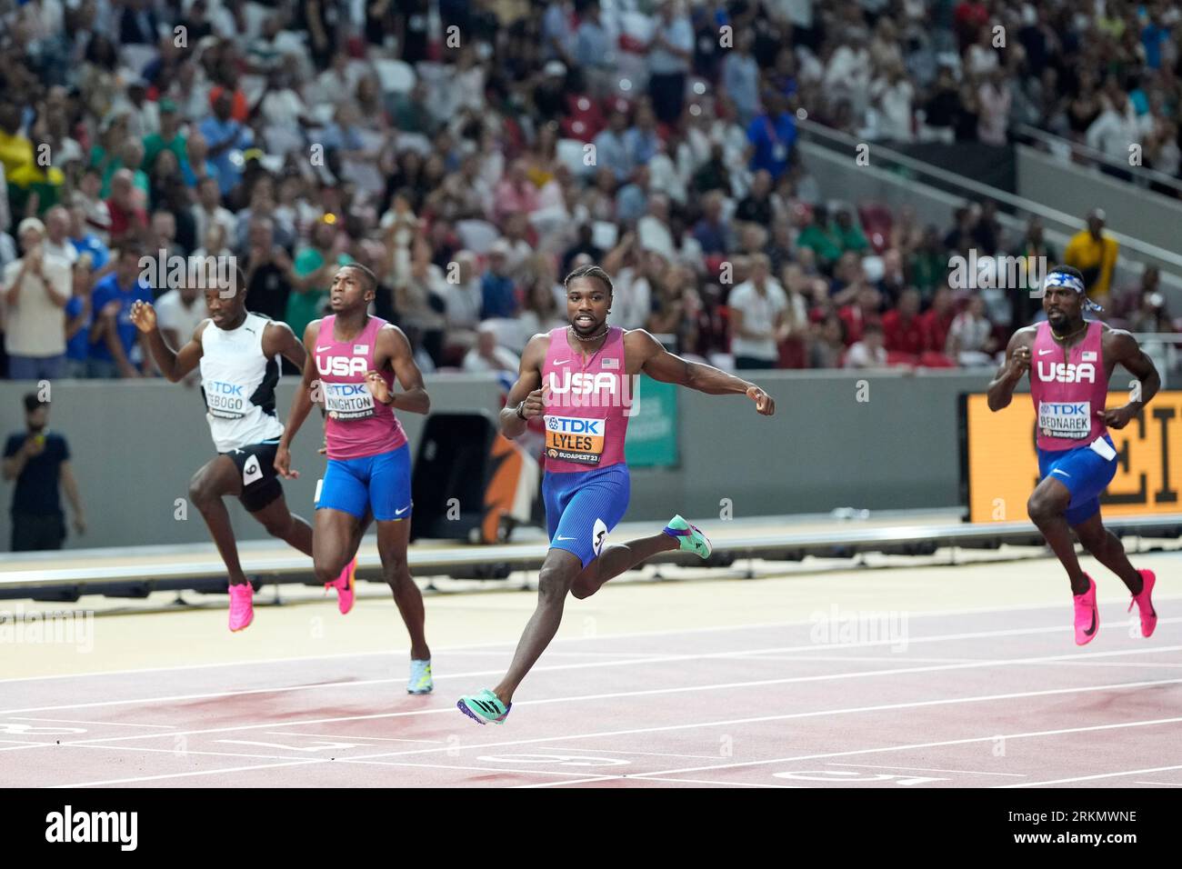 Noah Lyles, of the United States, center, crosses the finish line to ...