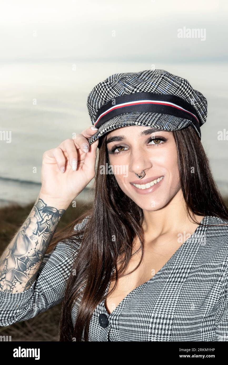 Youthful Urban Elegance: Confident Brunette in a Short Dress and Hat ...