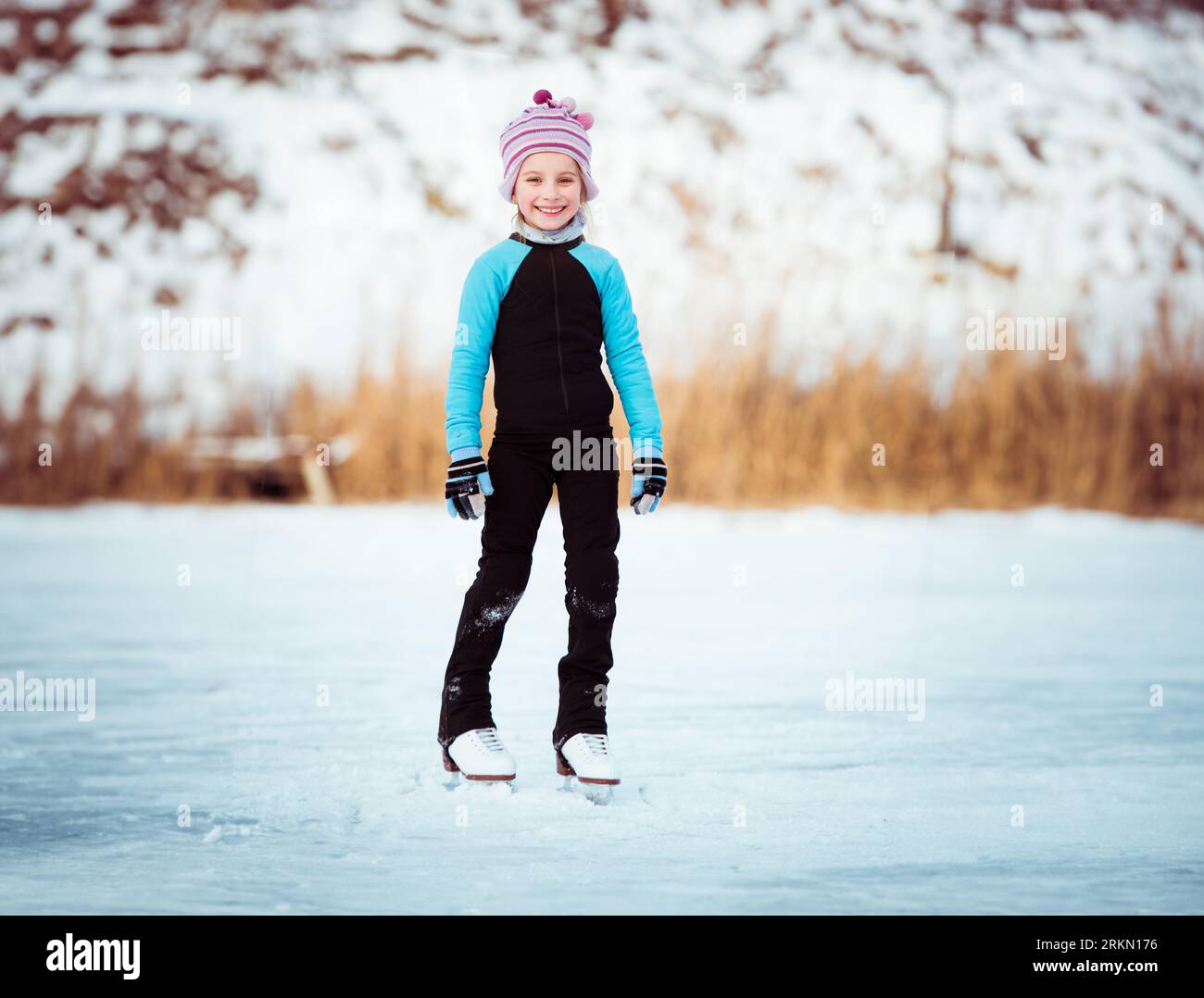 smiling cute little girl in thermal suits skating outdoors Stock Photo ...