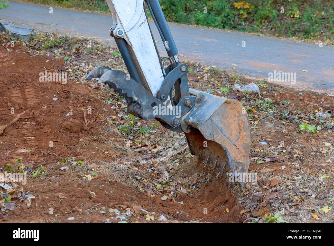 Digging ditch with tractor to accommodate drainage concrete sewage a ...