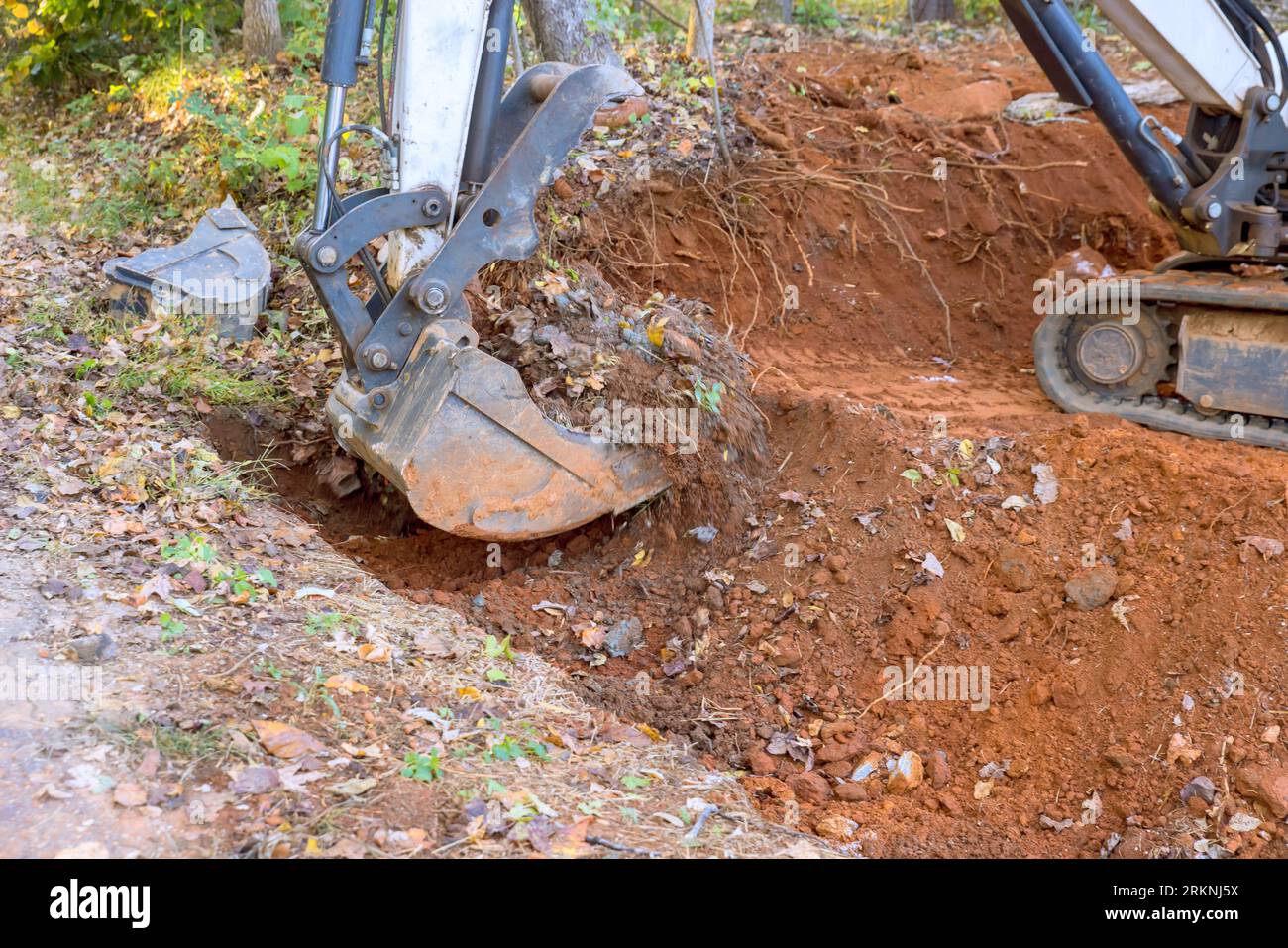 Worker use tractor digs out ditch for laying drainage concrete sewage ...
