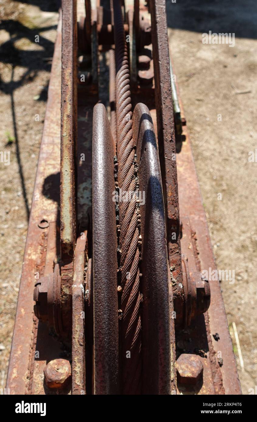 Rusty old steel cable wrapped around old pulley Stock Photo - Alamy