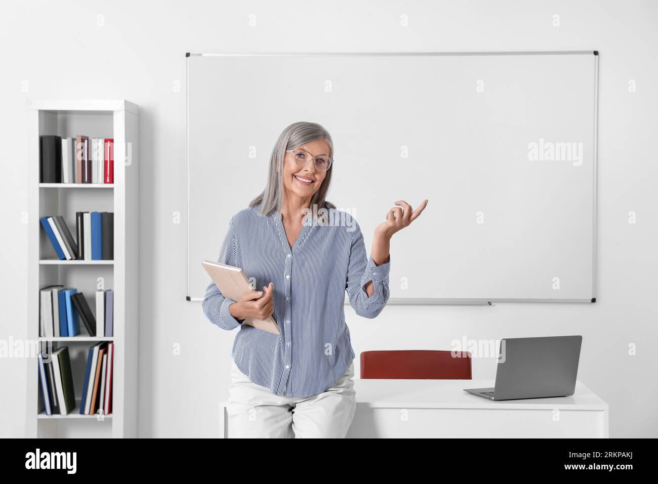 Portrait of happy professor near whiteboard in classroom Stock Photo ...