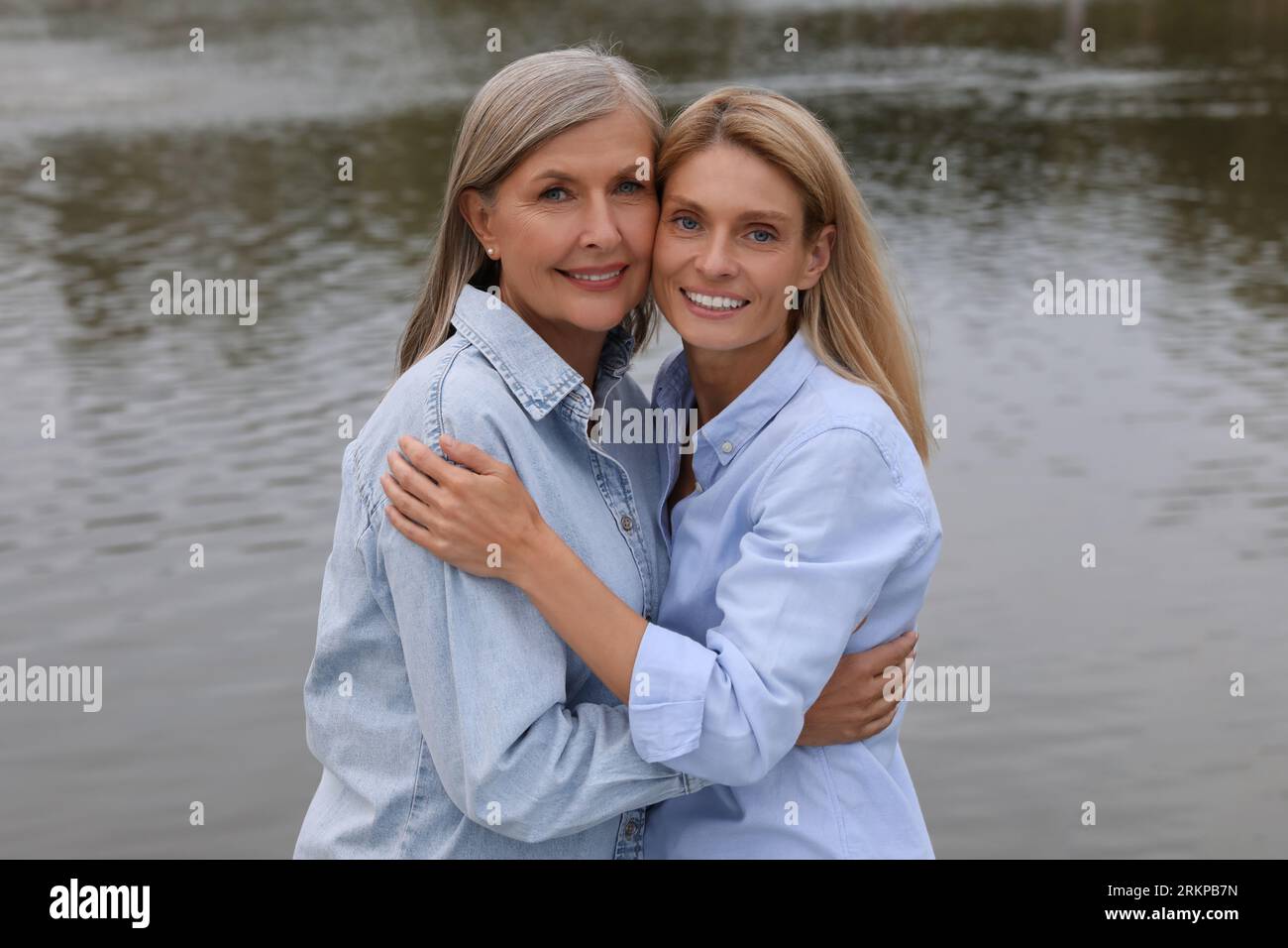 Happy mature mother and her daughter hugging near pond Stock Photo - Alamy