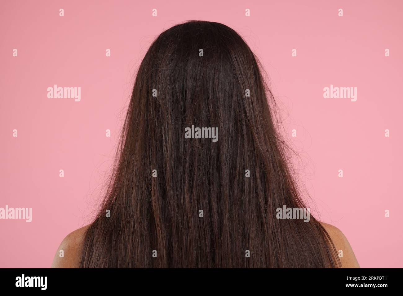 Woman with damaged messy hair on pink background, back view Stock Photo ...