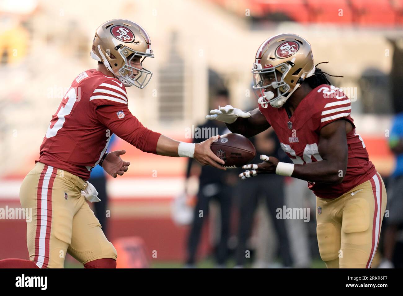 San Francisco 49ers quarterback Brock Purdy, left, hands off to running ...