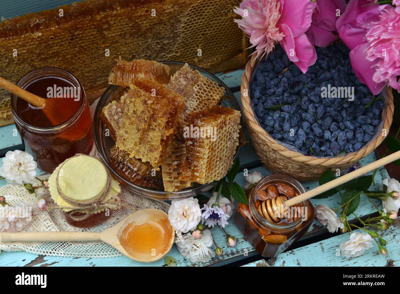 Still life with natural honey in jar, honeycomb cut in pieces and ...