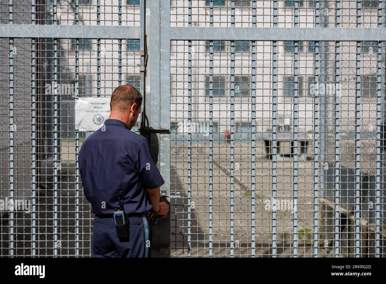 Nuremberg, Germany. 24th Aug, 2023. An employee of Nuremberg Prison (JVA) opens an access gate ...