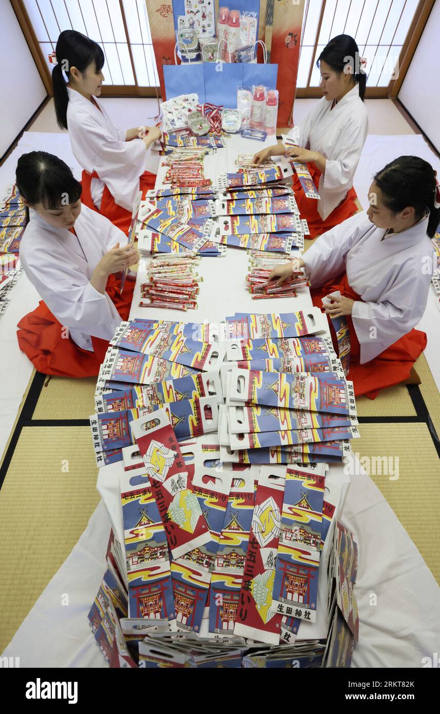 Shrine maidens prepare chitoseame, a Japanese traditional red and white ...