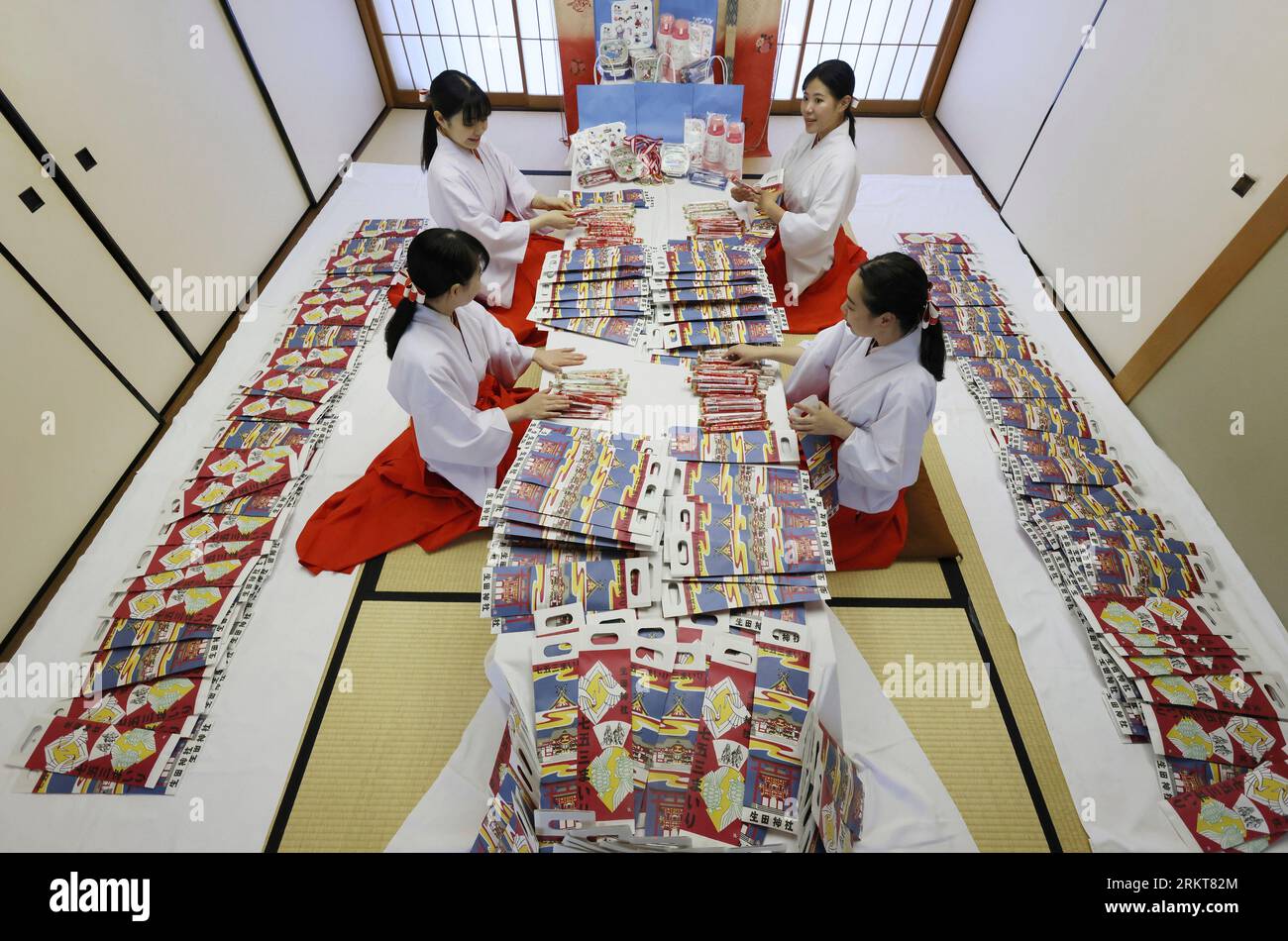 Shrine maidens prepare chitoseame, a Japanese traditional red and white ...