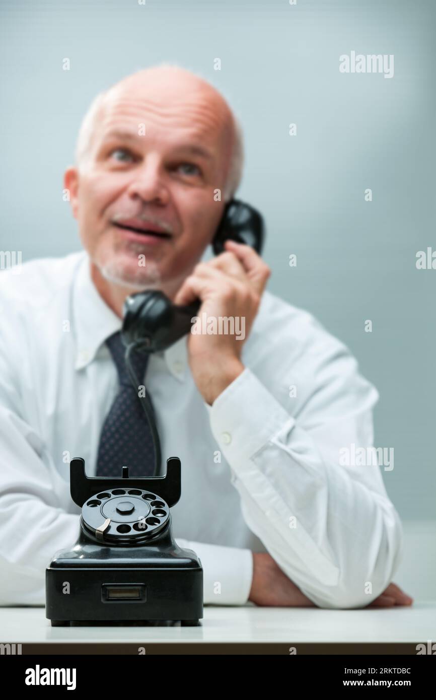 Prominently displayed black rotary phone contrasts with an animated ...