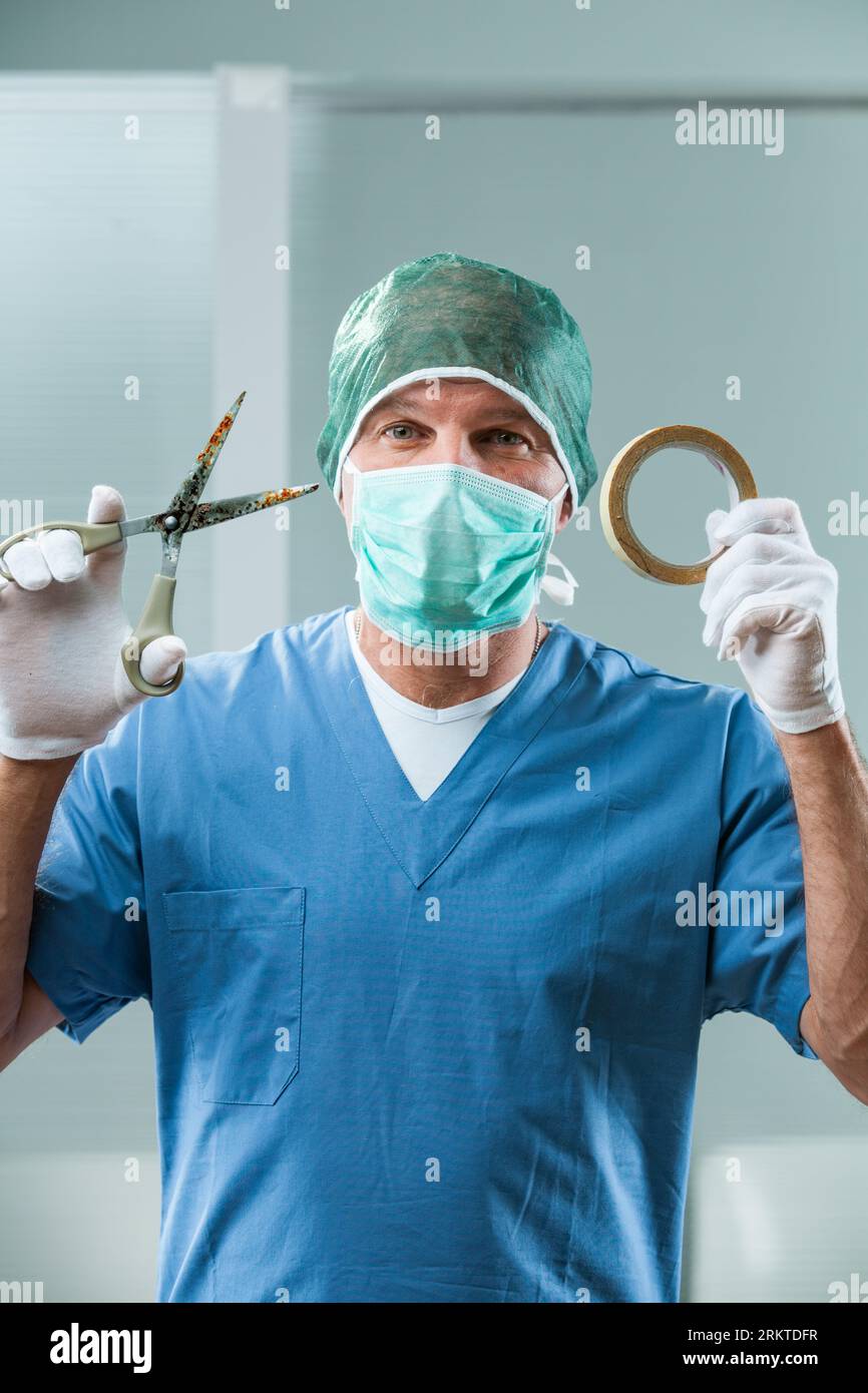 Surgeon in an operating room uses rusty scissors and paper tape. His ...