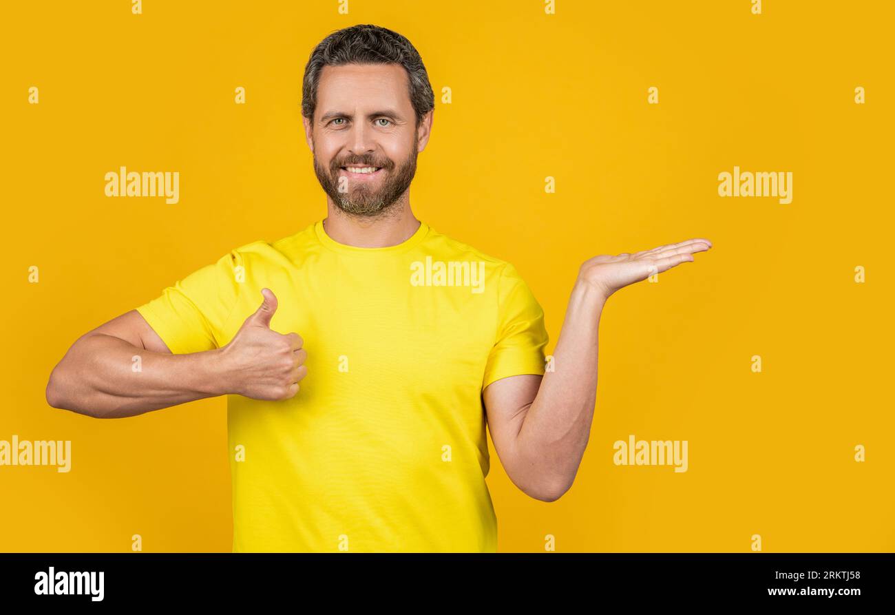 photo of smiling man presenting advertisement, thumb up. man presenting ...