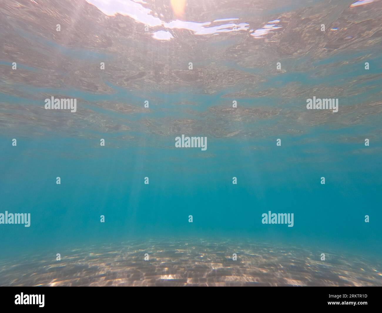 Pure water. Under the water, the rays of the sun and the sandy bottom ...