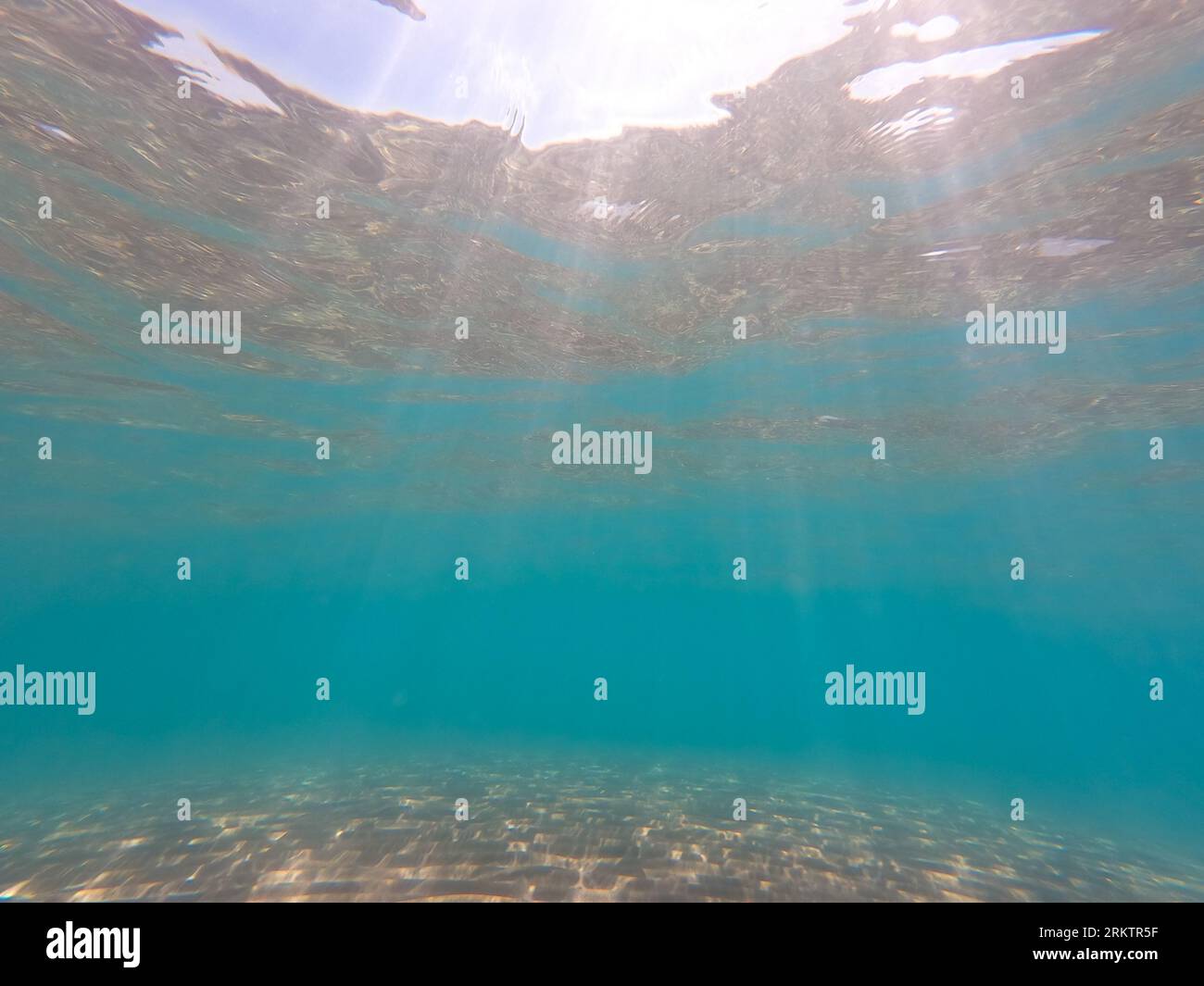 Pure water. Under the water, the rays of the sun and the sandy bottom ...