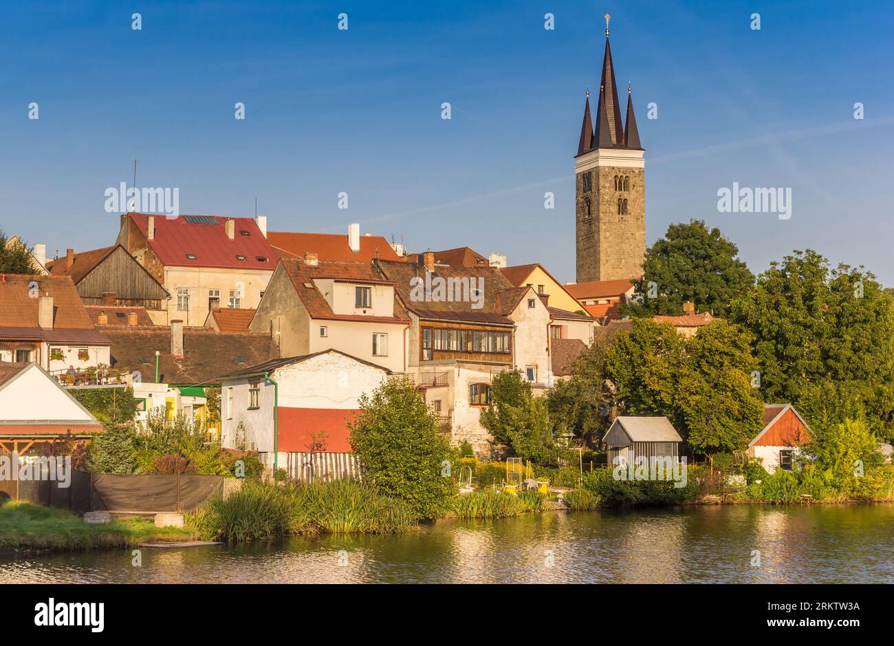 Church tower and houses at the lake in Telc, Czech Republic Stock Photo ...