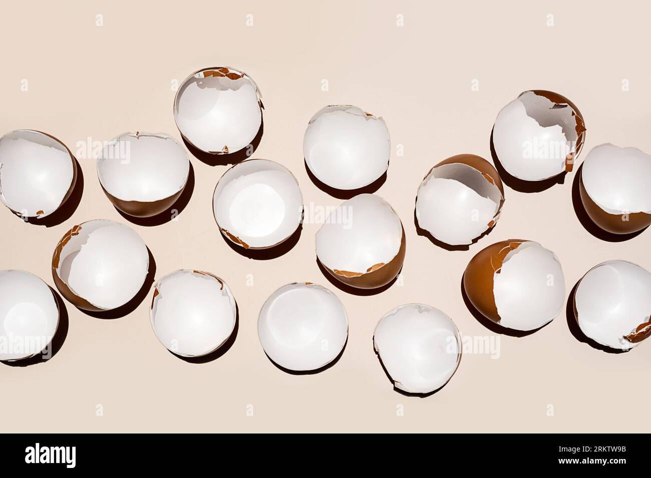Cracked eggshell arranging on neutral background Stock Photo - Alamy