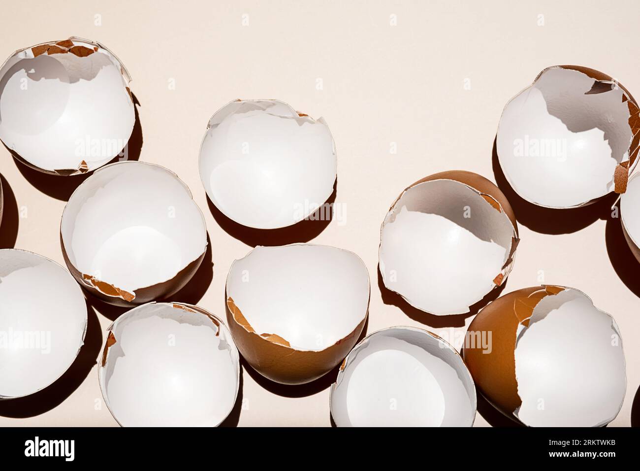 Cracked eggshell arranging on neutral background Stock Photo - Alamy