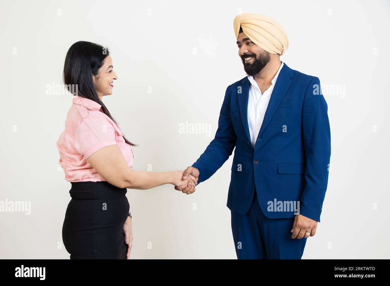 Young indian sikh business man shake hand with woman isolated over ...