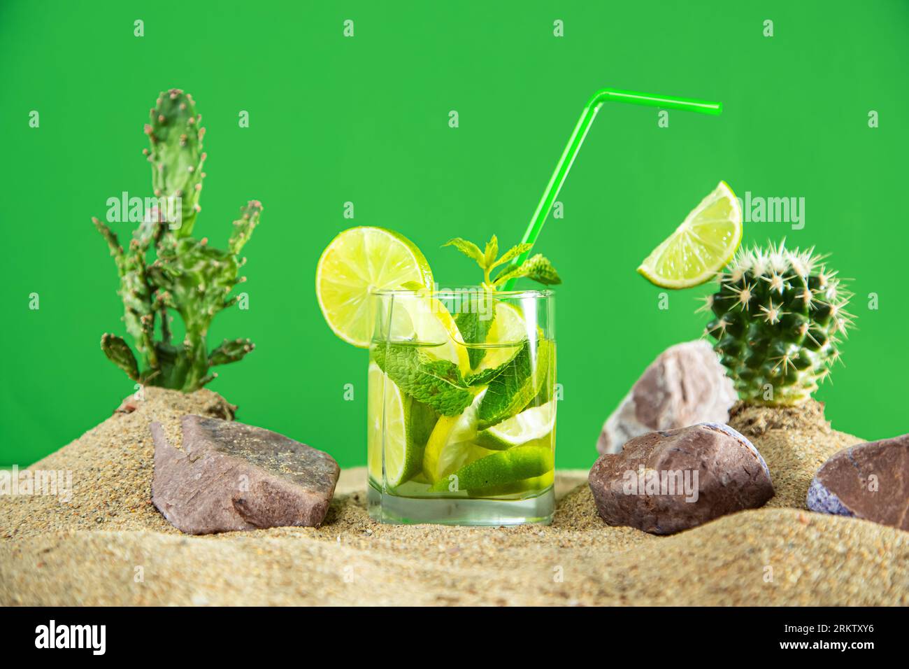 Glass of lemonade with lime and mint among the sand dunes and cacti ...