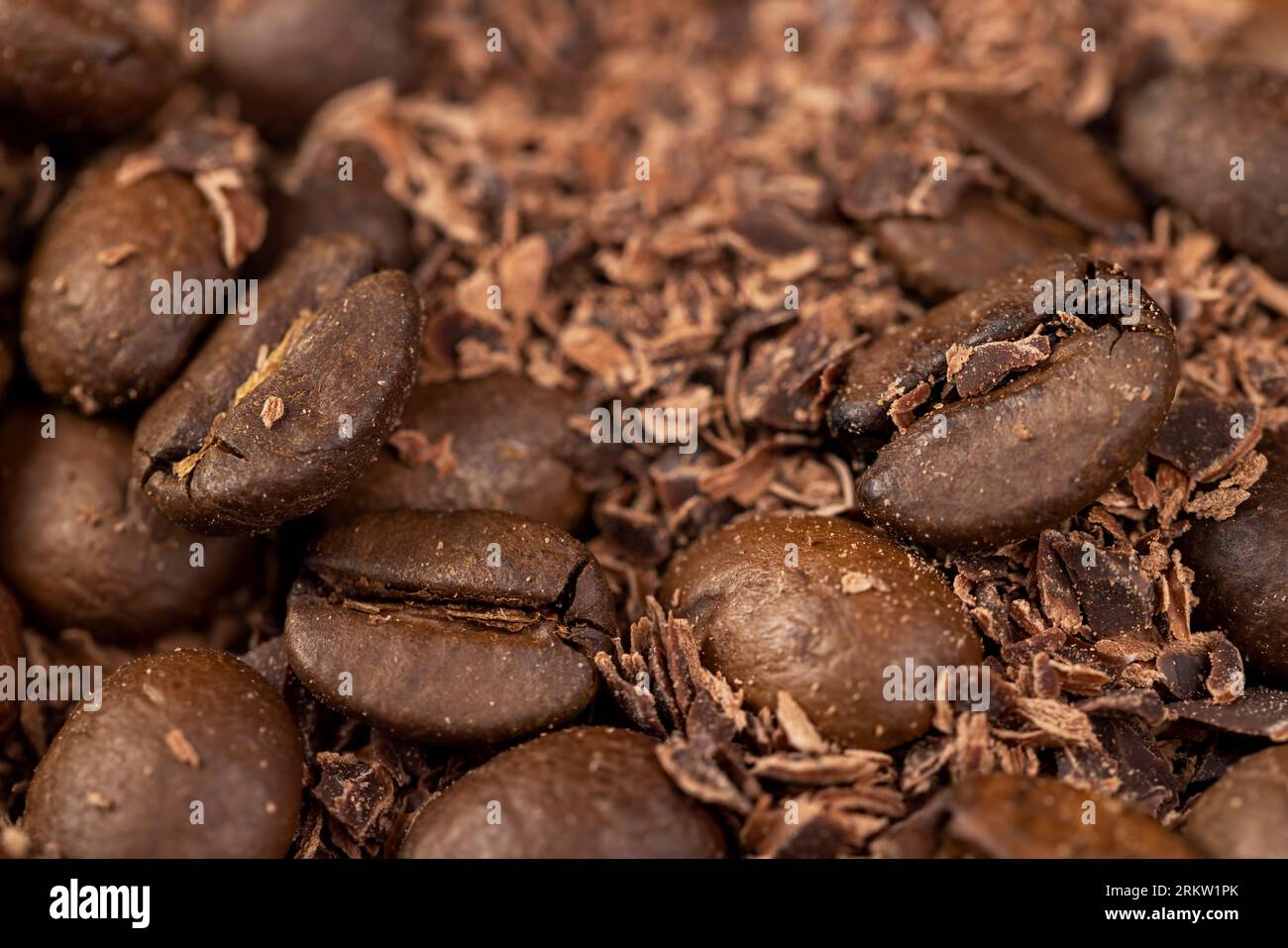 Roasted coffee beans lie together with chocolate crumbled into small ...