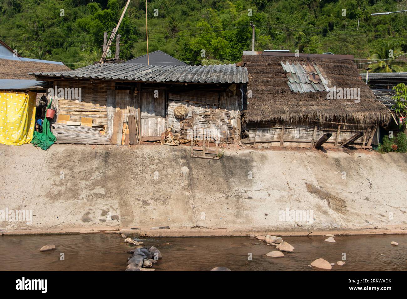 Primitive houses on the river bank in the village Stock Photo - Alamy