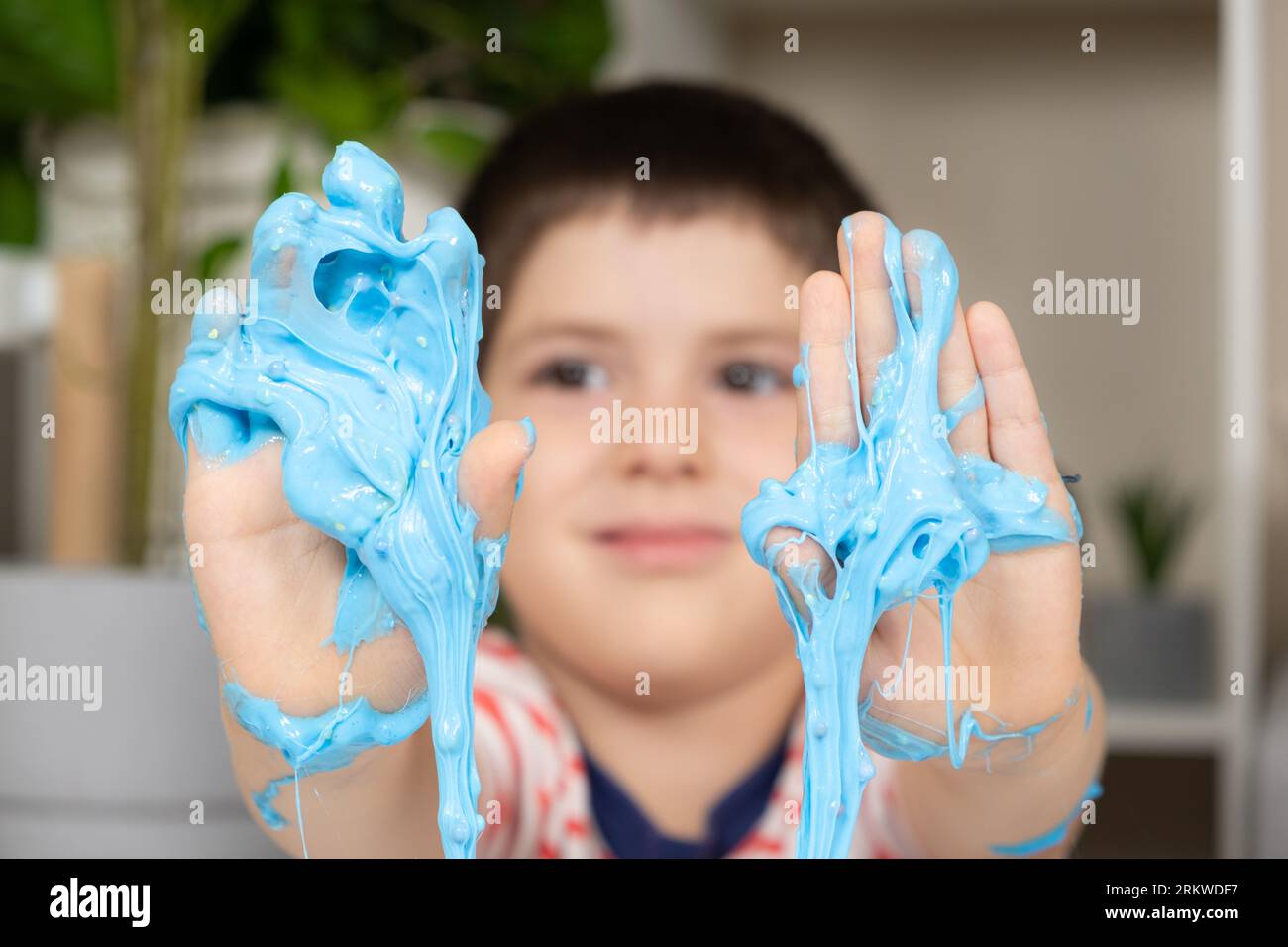 A primary school child plays with a slime, a pully sticky toy for the ...