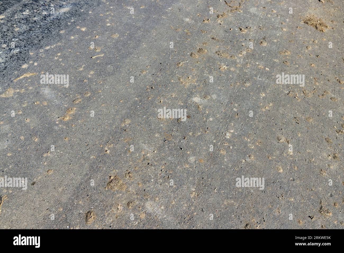 Details of a road polluted with sand and debris from fields, sand and ...