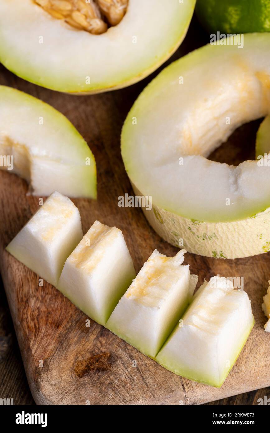 Cut into pieces ripe yellow melon with sweet pulp, cut melon on kitchen ...