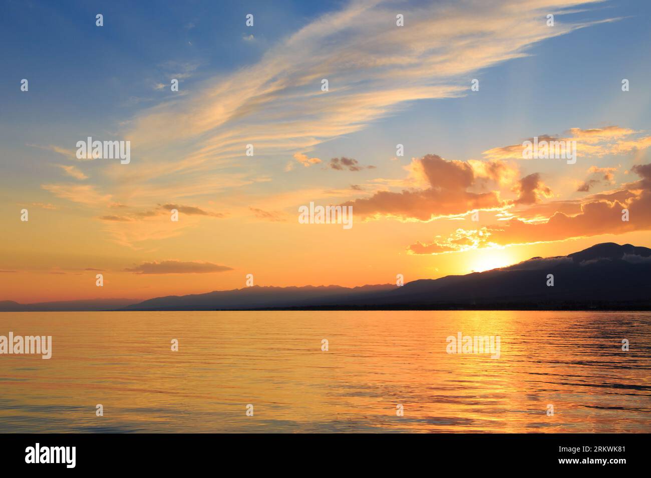Colorful sea beach over mountains sunrise with deep blue sky and ...