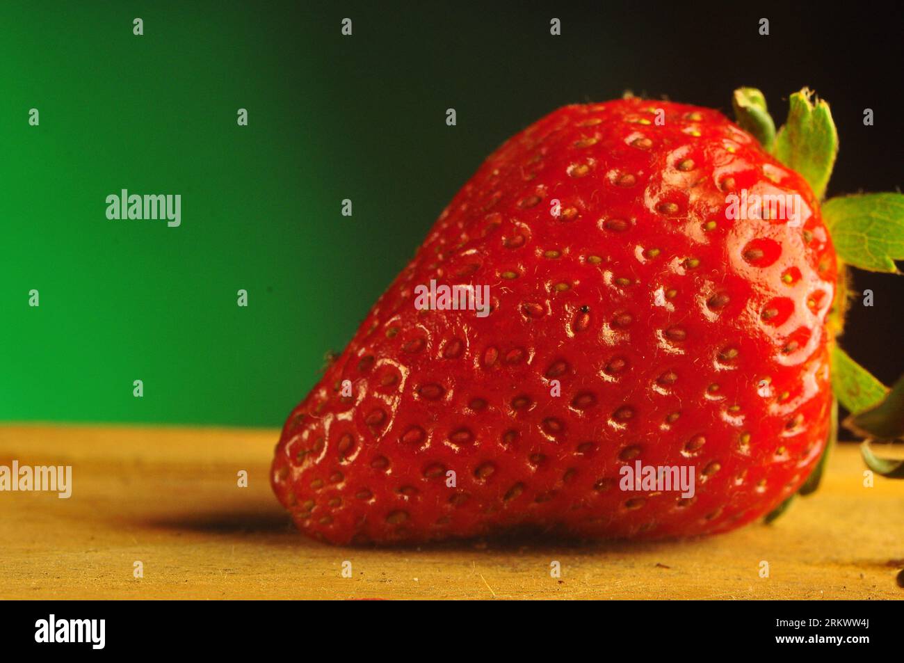 Strawberry fruit close up on studio shot, green background Stock Photo ...