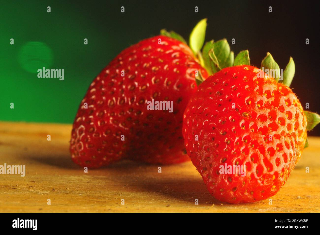 Strawberry fruit close up on studio shot, green background Stock Photo ...