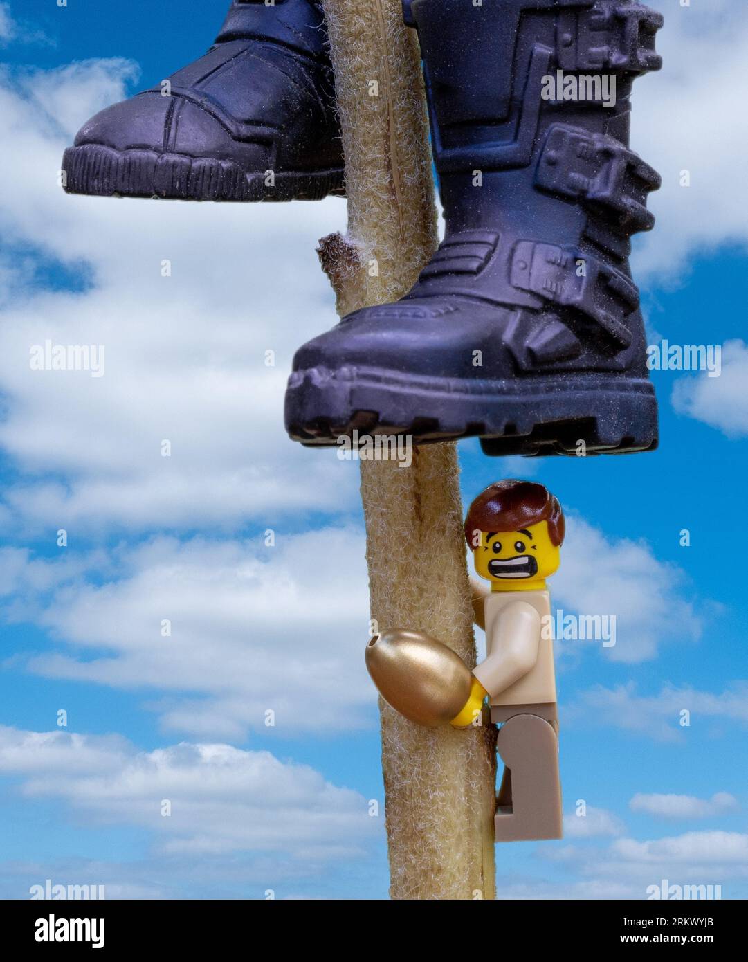 An image of a small Lego figurine of a man scaling a stick located ...