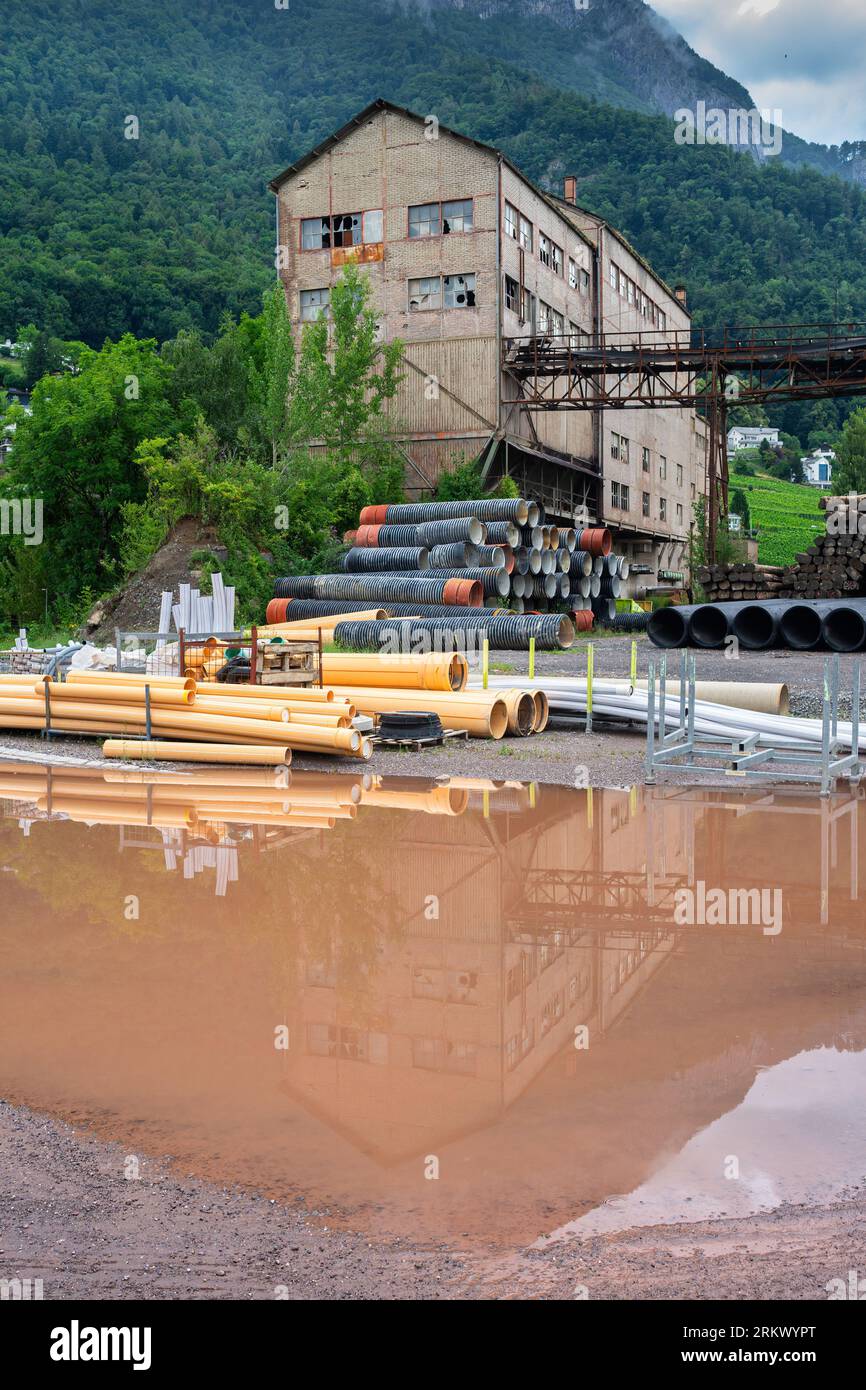 An abandoned factory in Sargans and its reflection in a puddle Stock ...
