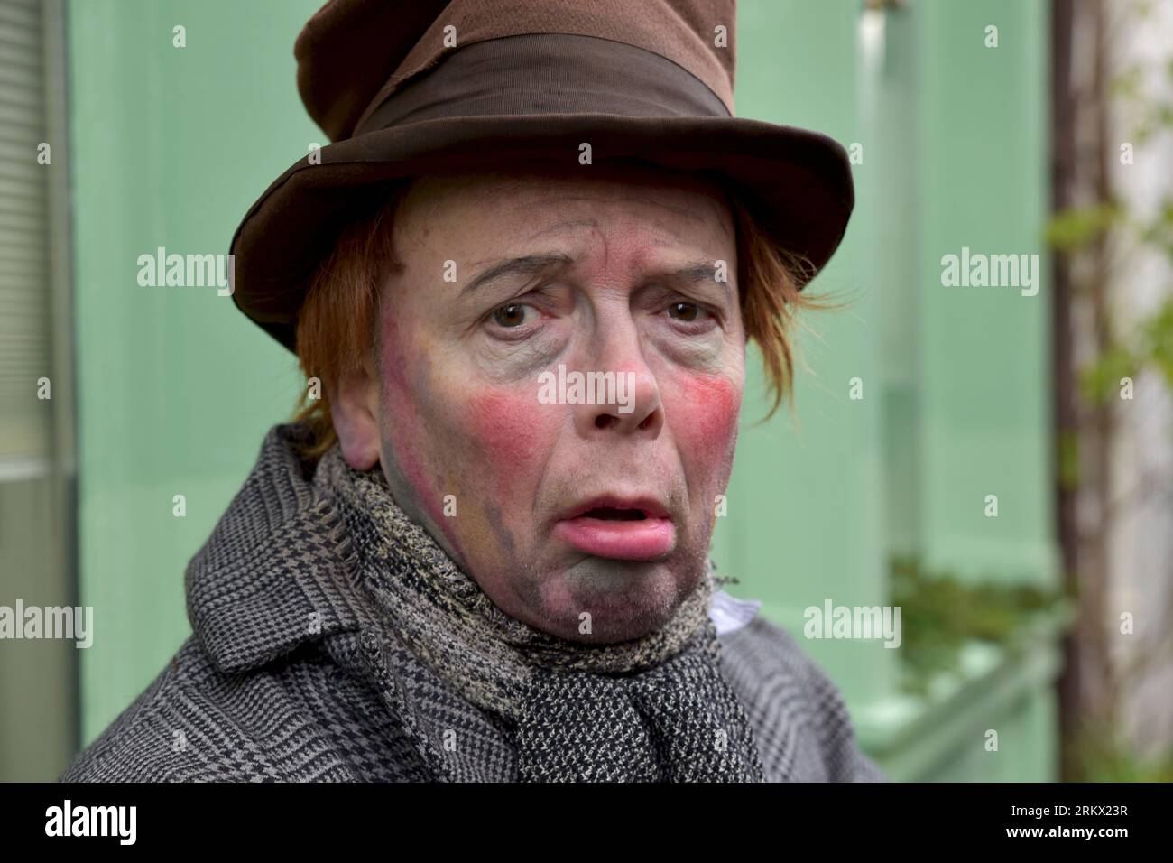 Actor with a brown hat and red spiked hair plays a drunken bum during ...