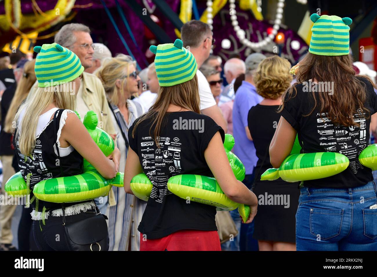 Three girls with green striped hats and floaties around their waists ...