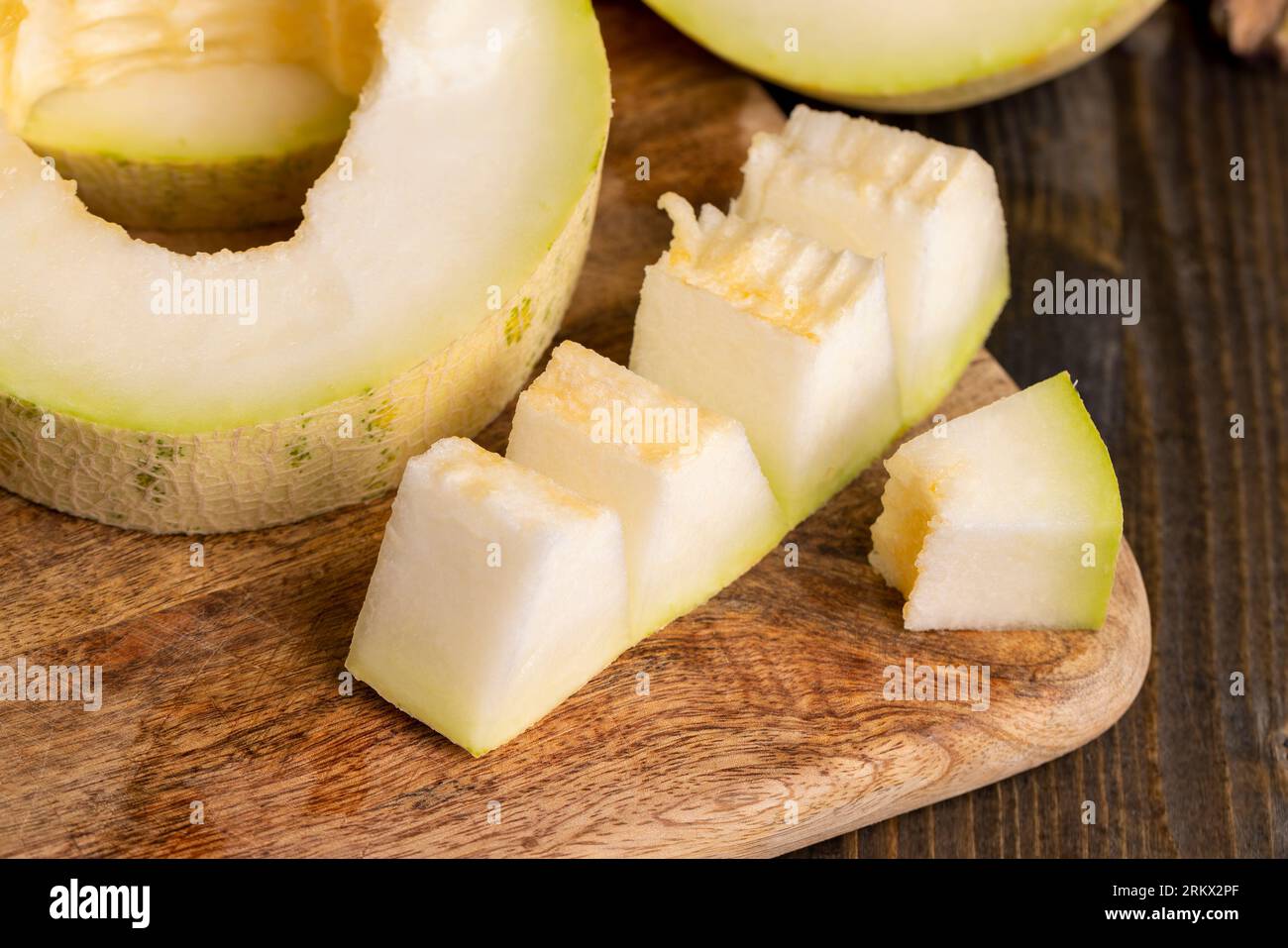 Cut into pieces ripe yellow melon with sweet pulp, cut melon on kitchen ...