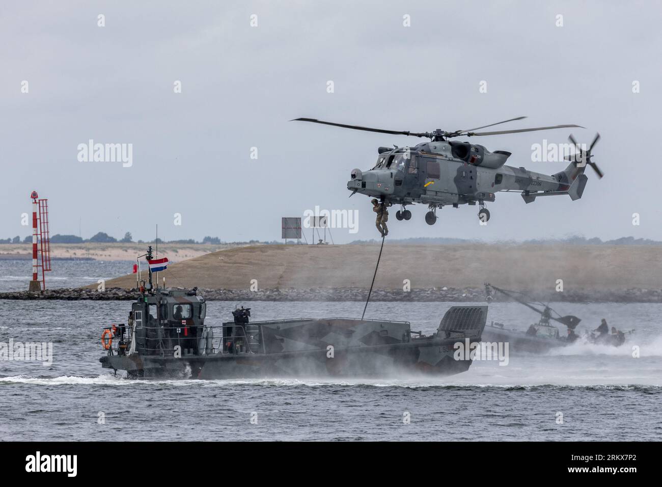 A military helicopter and two boats in a lake Stock Photo - Alamy