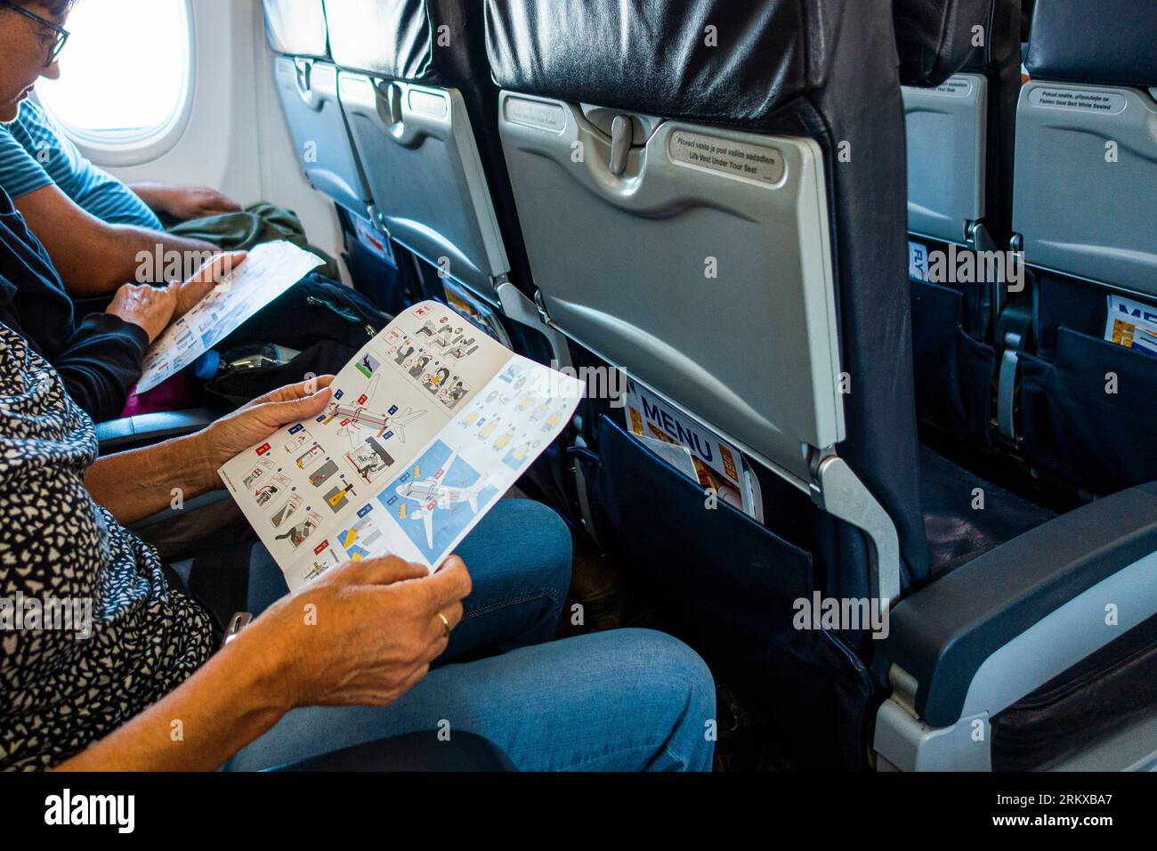 A passenger study safety precautions leaflet on Travel Service plane ...