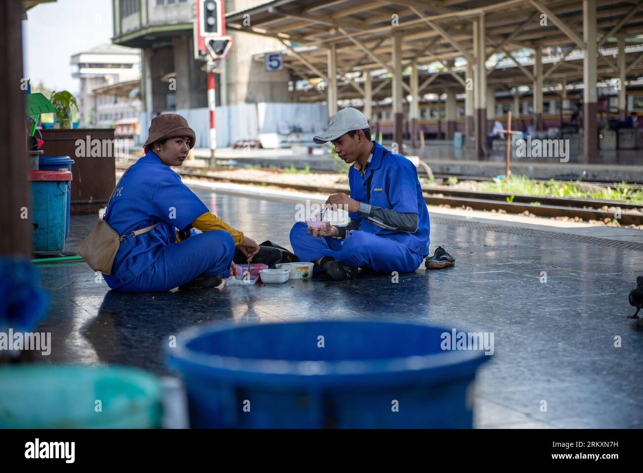 Bangkok, Thailand - March 6th 2020: Two railway workers sit on the ...