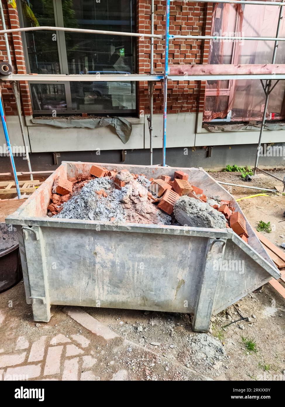 A Container With Rubble In Front Of A Construction Site Stock Photo - Alamy
