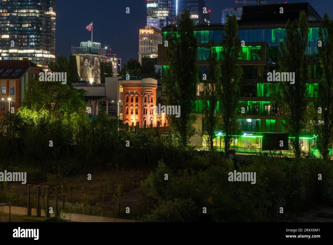Night city lights. View of the Warsaw Uprising Museum. New houses glow ...