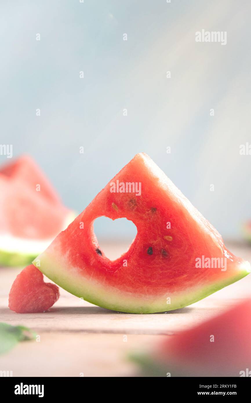 A cut piece of watermelon with a heart-shaped hole. concept Summer, joy ...