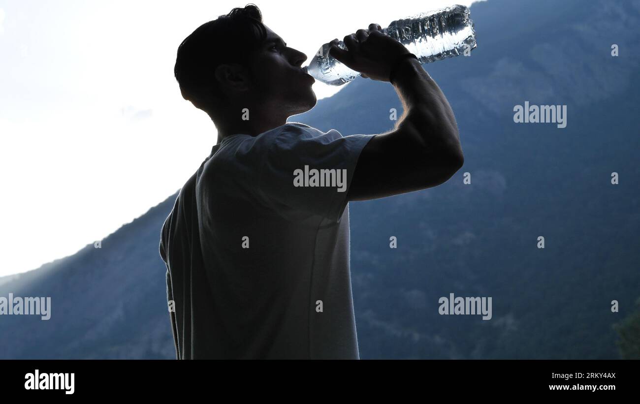 Photo of a man quenching his thirst with a refreshing drink from a ...