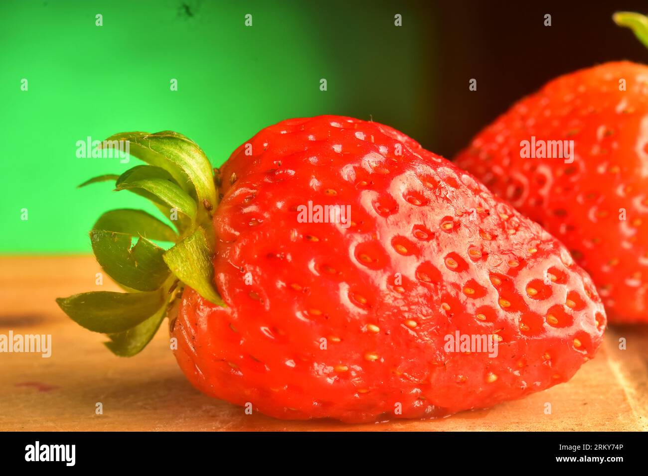 Strawberry fruit close up on studio shot, green background Stock Photo ...