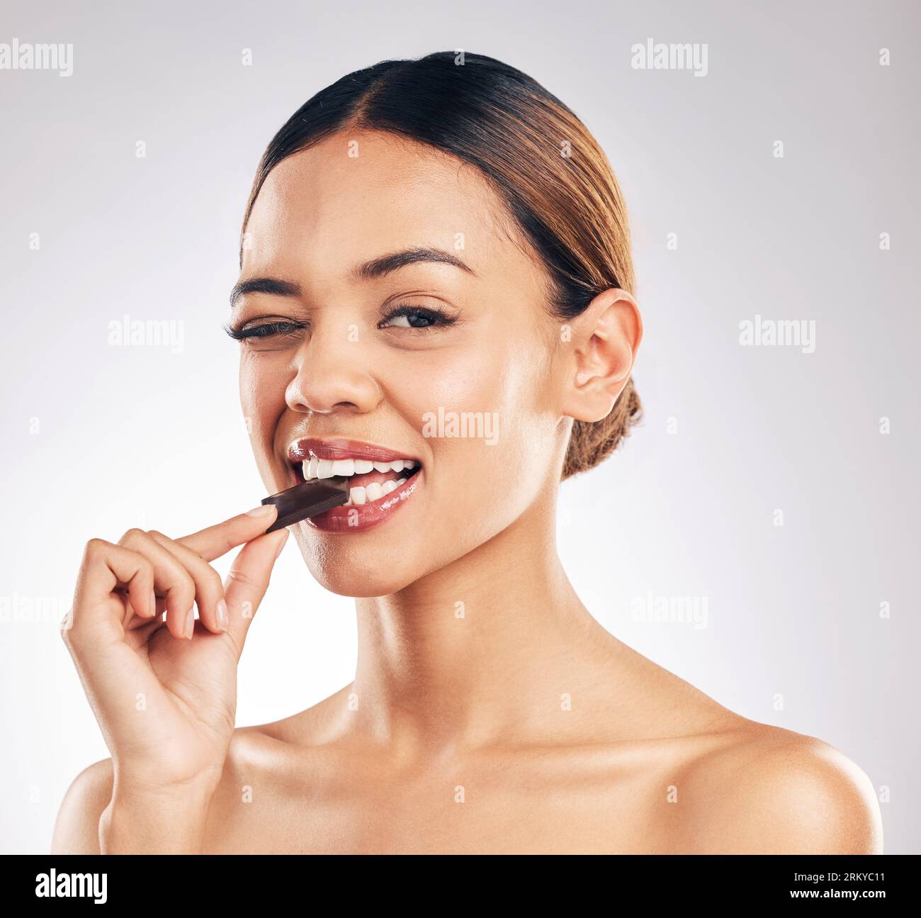 Chocolate, wink and portrait of woman in studio with diet, detox or ...